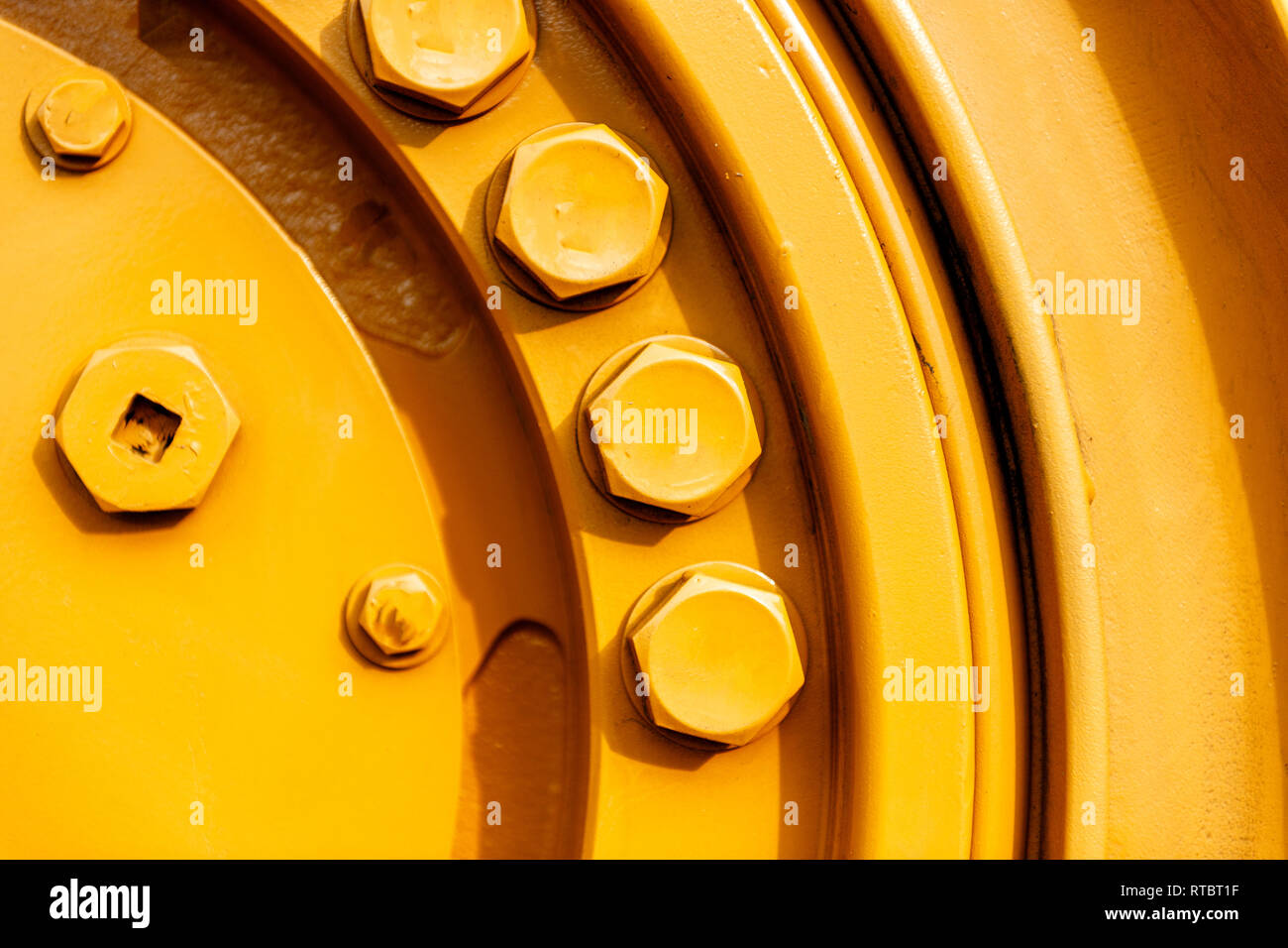 Large screw on the yellow tractor detail - powerful machinery on ...