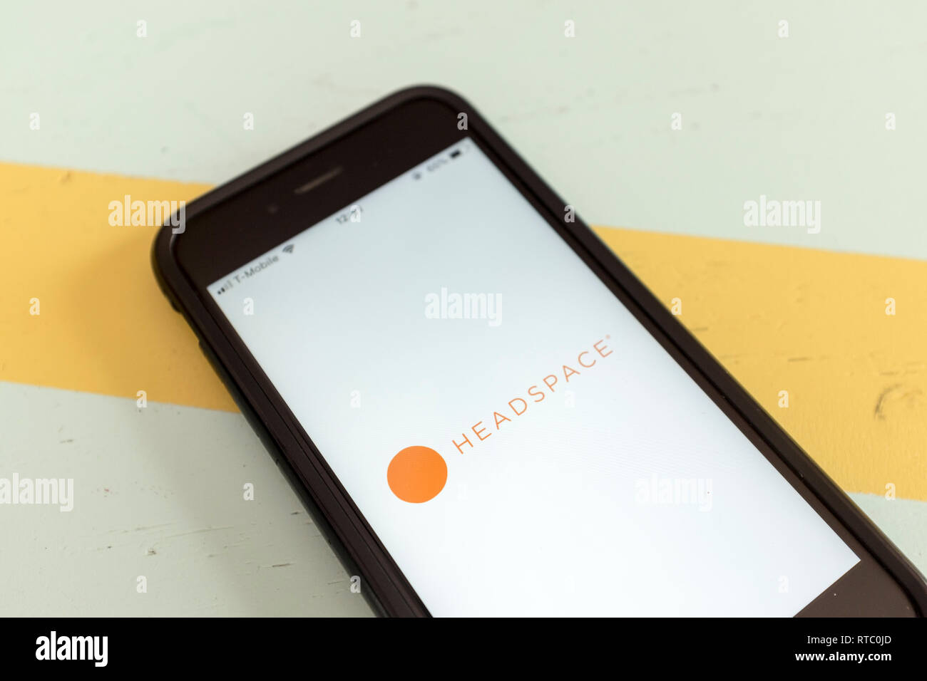 A closeup of a smartphone showing the app Headspace on a blue and ...