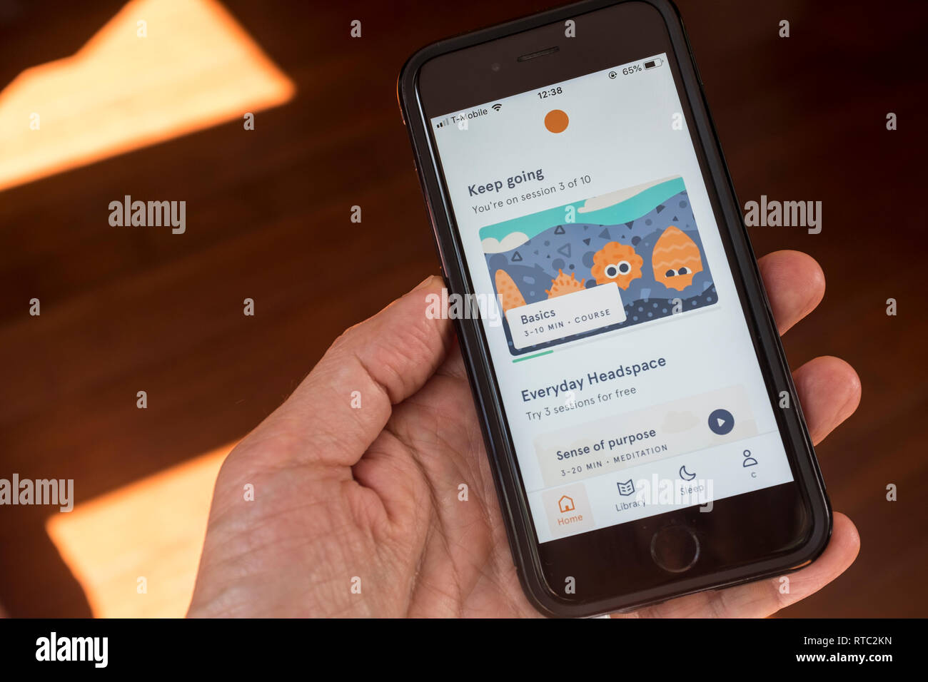 A man's hand holding a smartphone showing the app Headspace on the ...