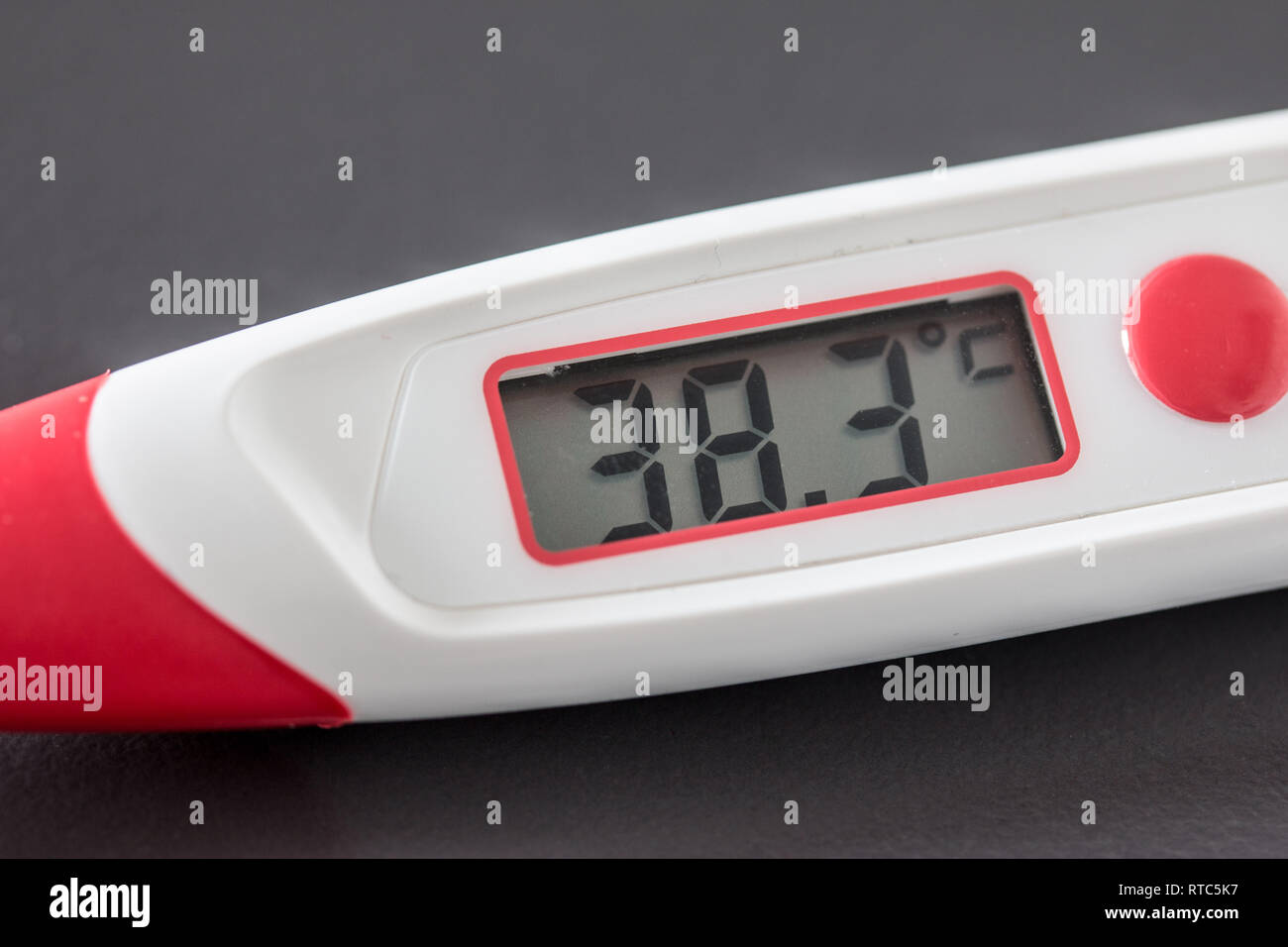 Red fever thermometer with digital display and 38 degrees Celsius lying ...
