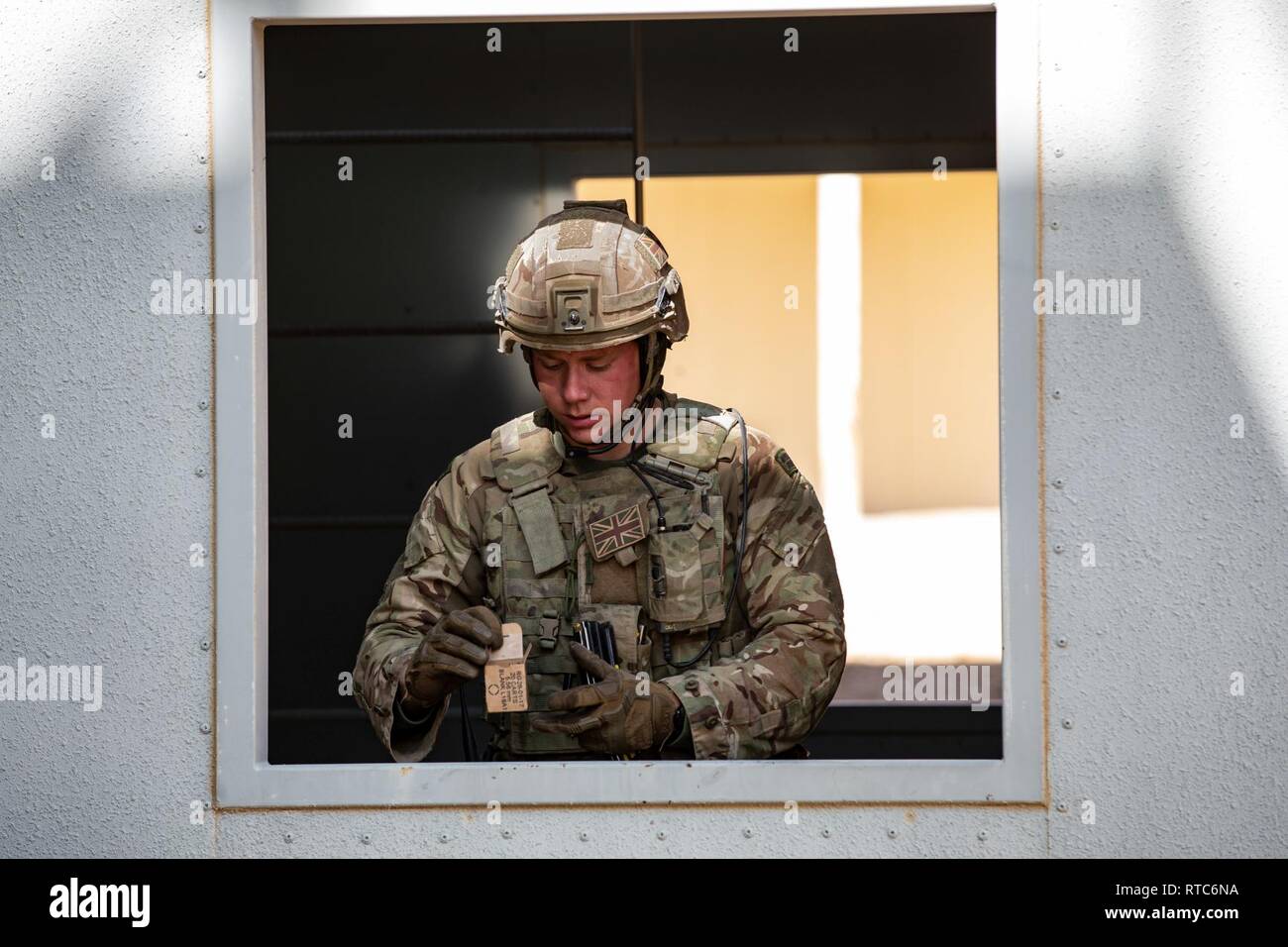 A U.K. Royal Marine with 45 Commando reloads his magazines during ...