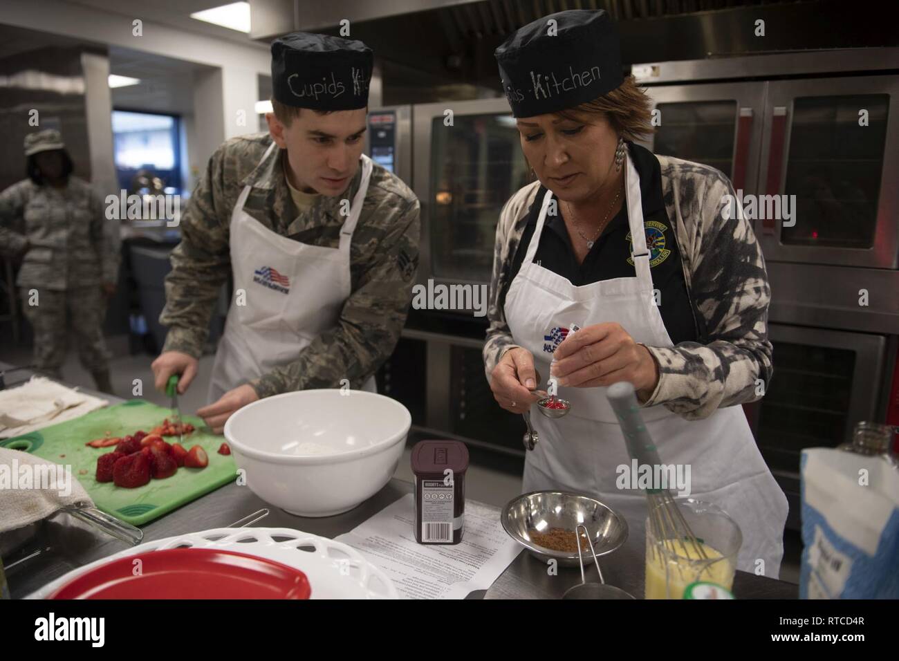 Senior Airman Christopher Nance and Heidi Williams, contestants, put ...