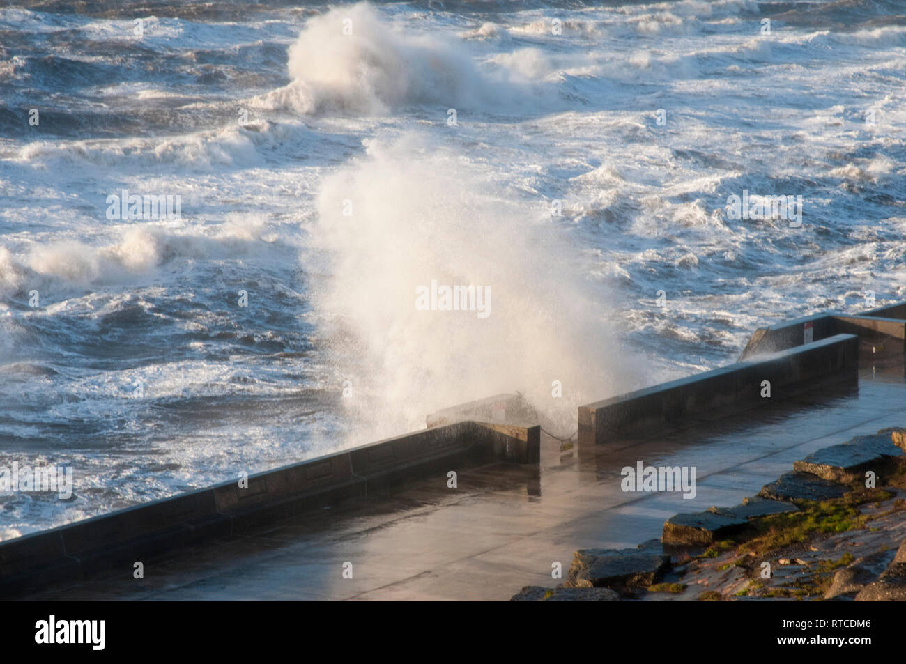 Waves crashing against the seawall in strong winds on north shore ...