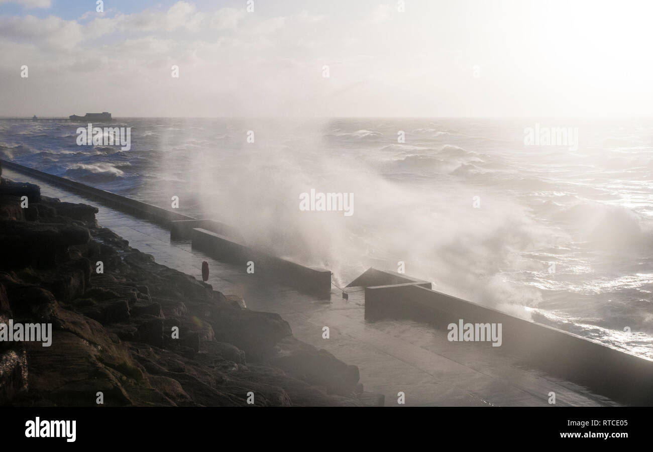 Waves crashing against the seawall in strong winds on north shore ...