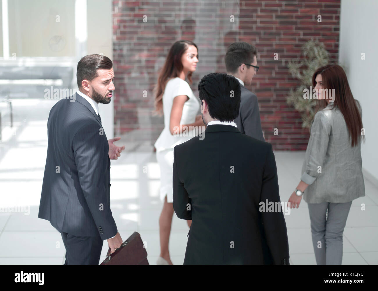 employees standing in the hall of a modern office Stock Photo - Alamy