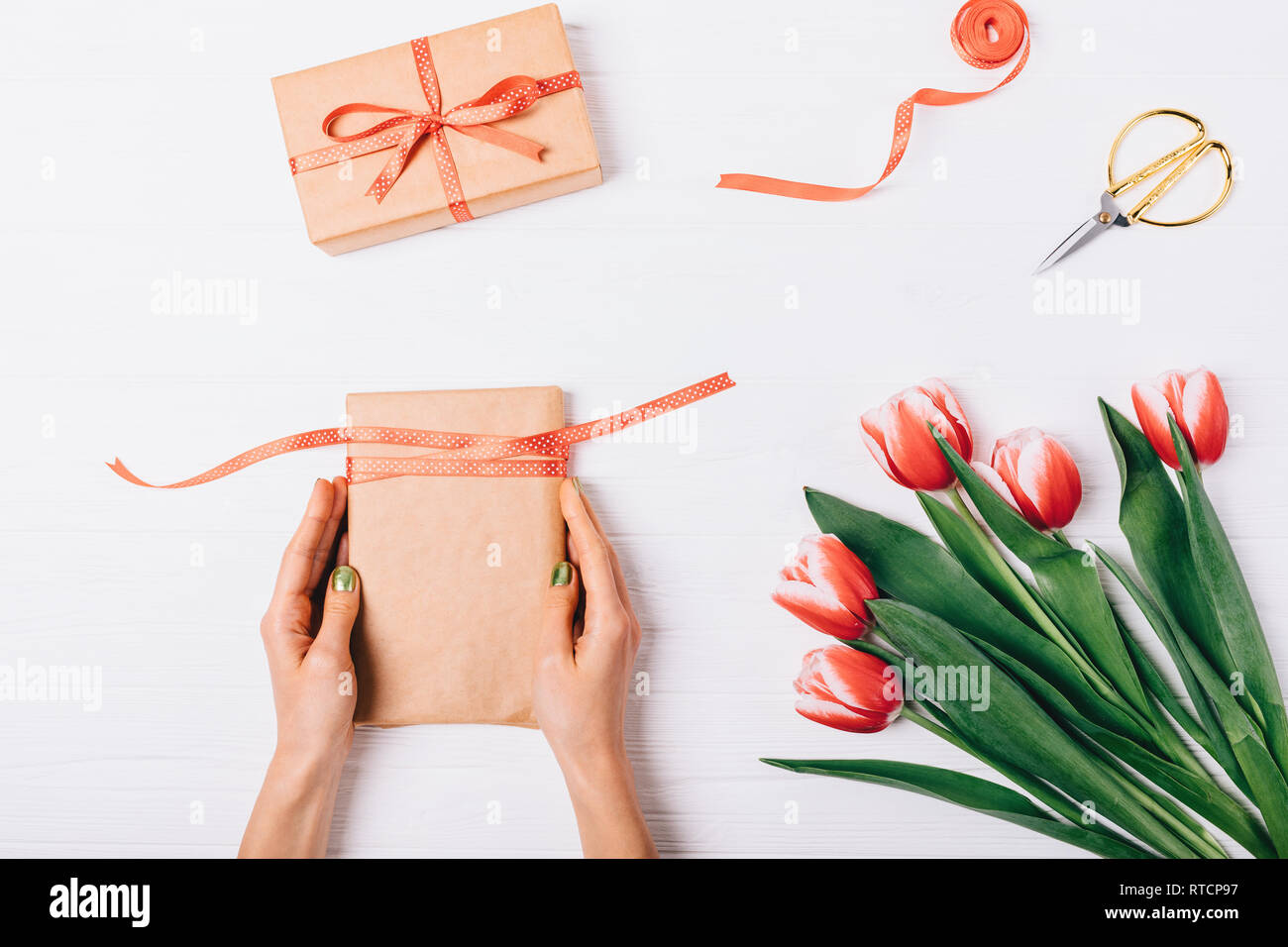 Process of packing gifts for holiday, flat lay. Top view of female's ...