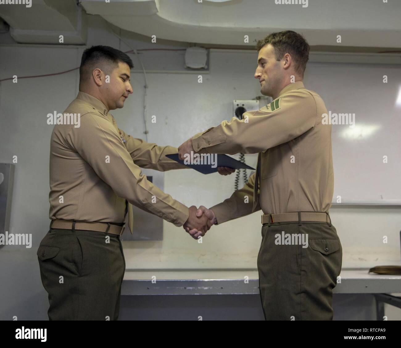 U.S. Marine Corps Capt. Alex Ayala, left, shakes hands with Cpl. Dallas ...