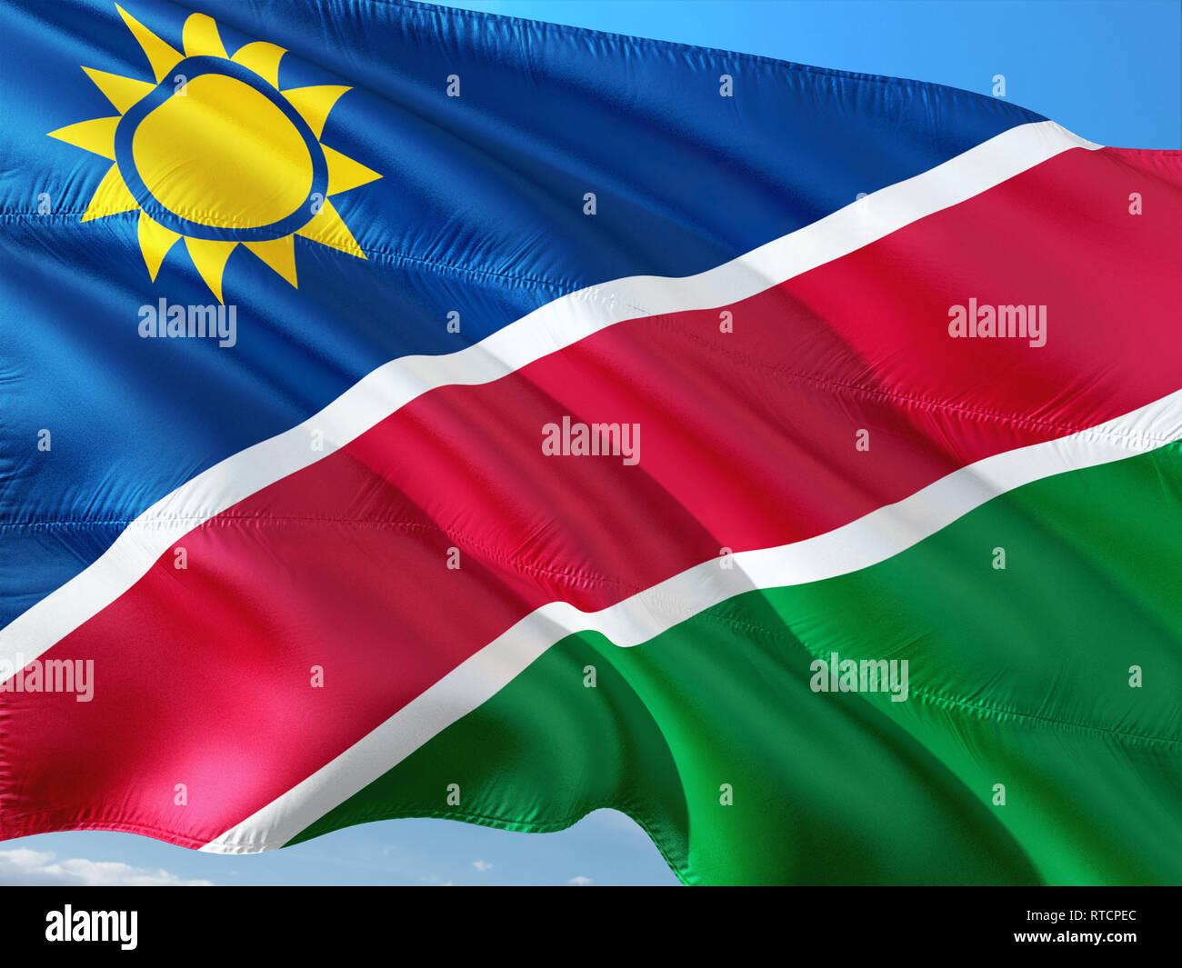 Flag of Namibia waving in the wind against deep blue sky. High quality ...