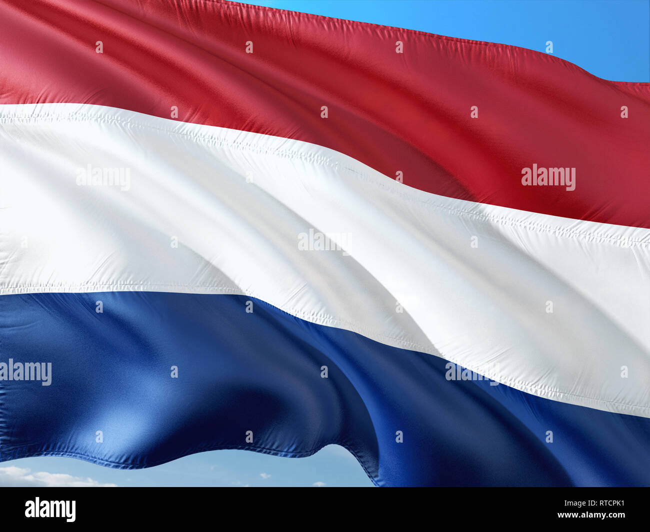 Flag of Netherlands waving in the wind against deep blue sky. High ...