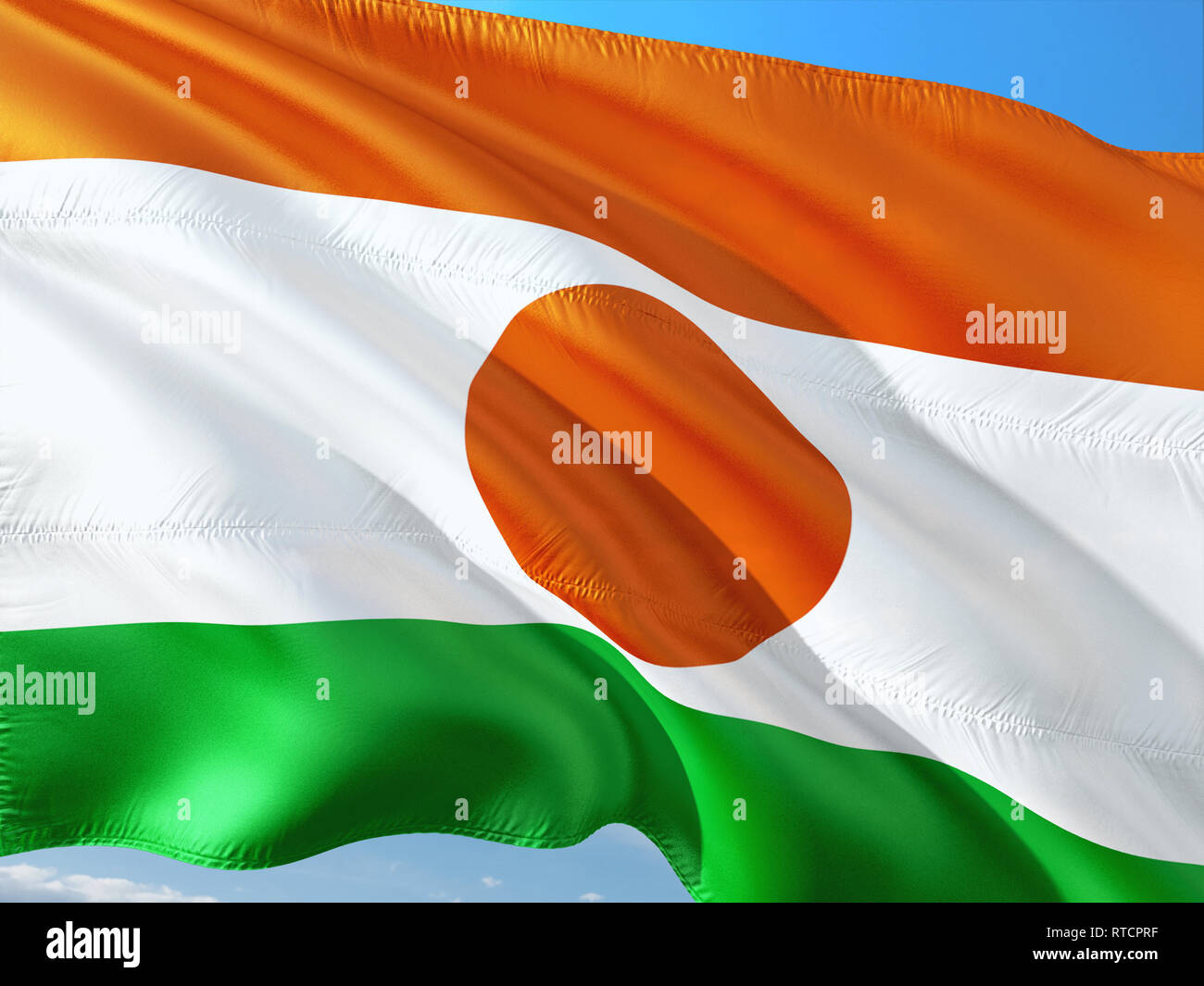 Flag of Niger waving in the wind against deep blue sky. High quality ...