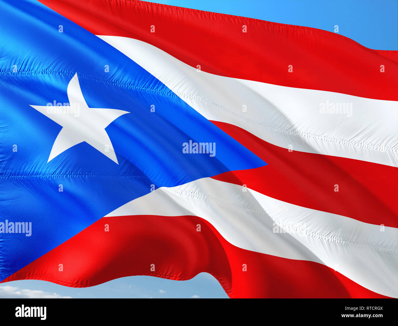 Flag of Puerto Rico waving in the wind against deep blue sky. High ...