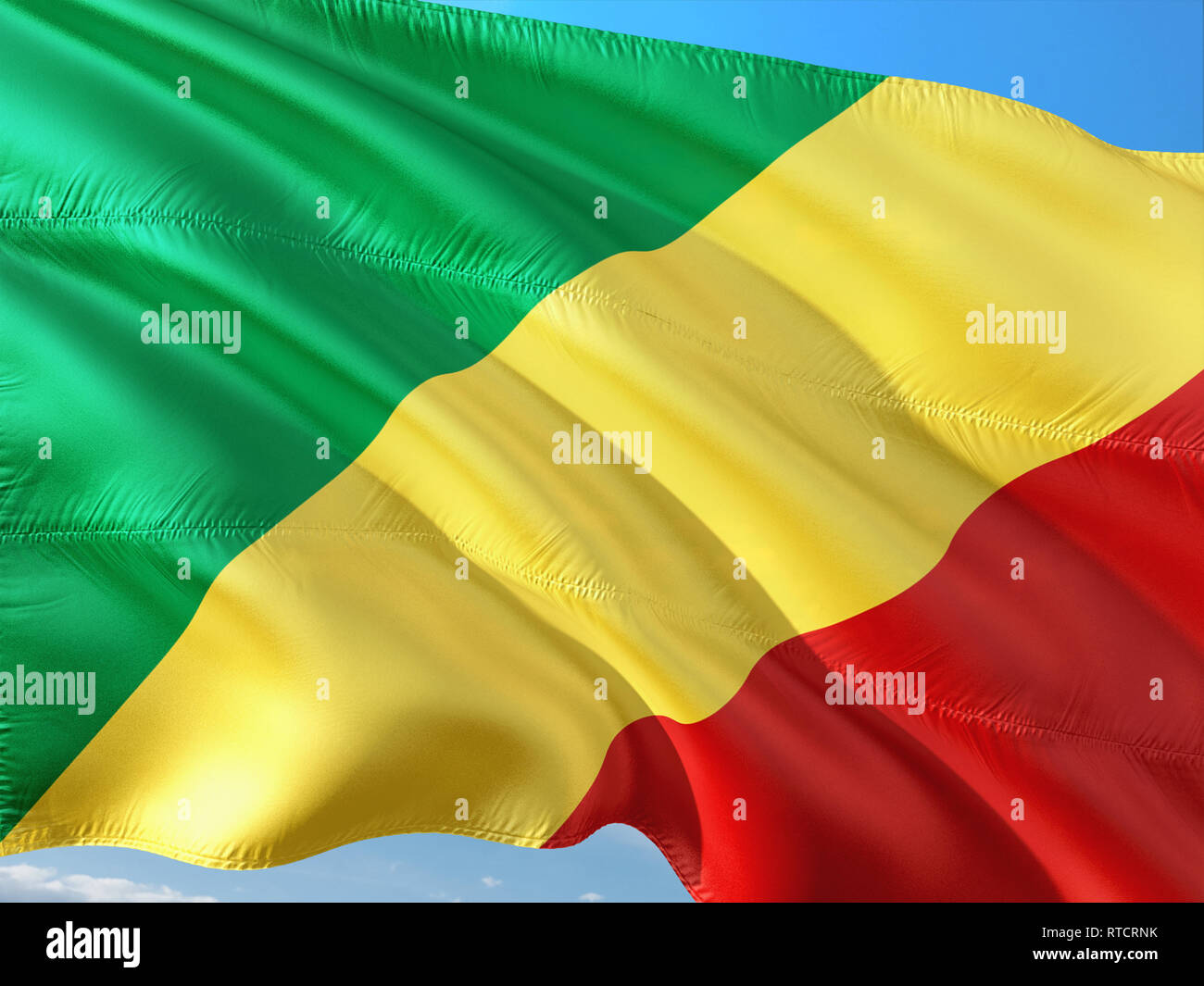 Flag of Republic Of Congo waving in the wind against deep blue sky ...