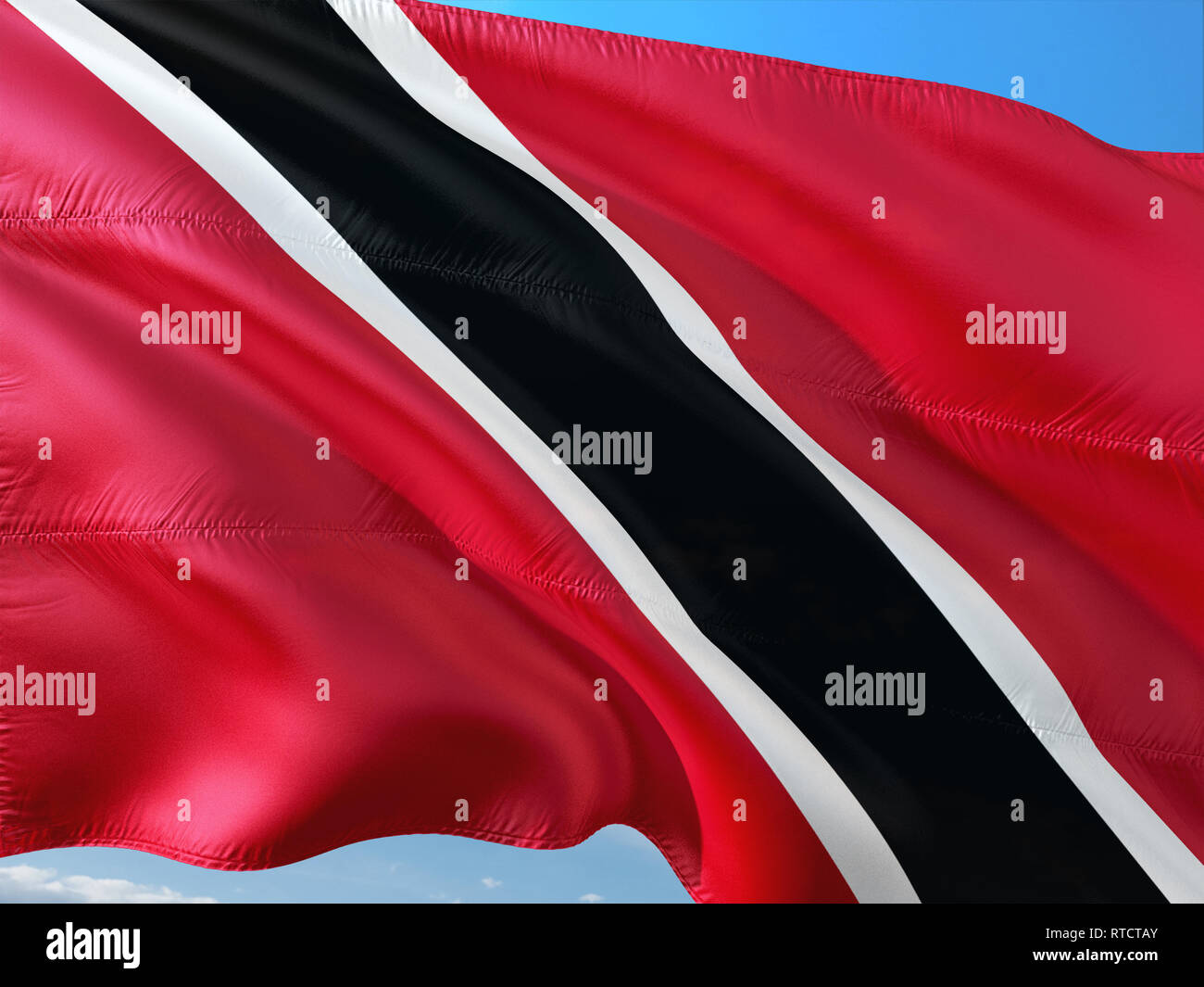 Flag of Trinidad and Tobago waving in the wind against deep blue sky ...
