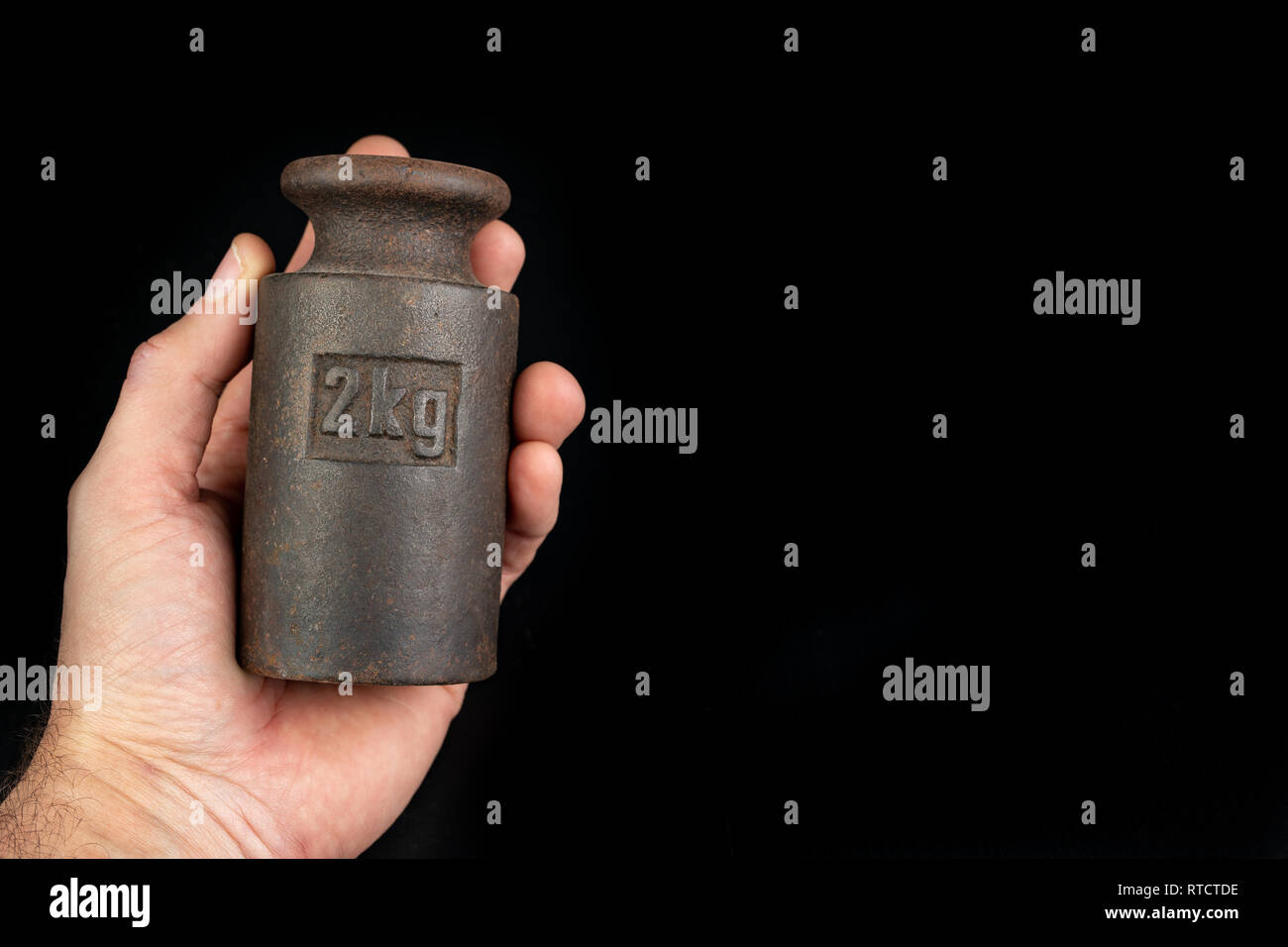 Old rusty metal weight for weighing products in the palm of your hand ...