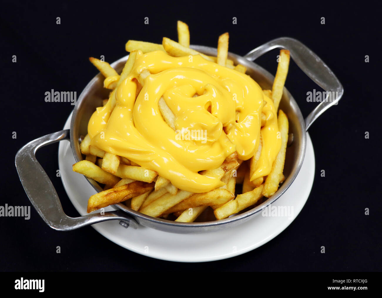 cheesy french fries on a metal plate with black background Stock Photo ...