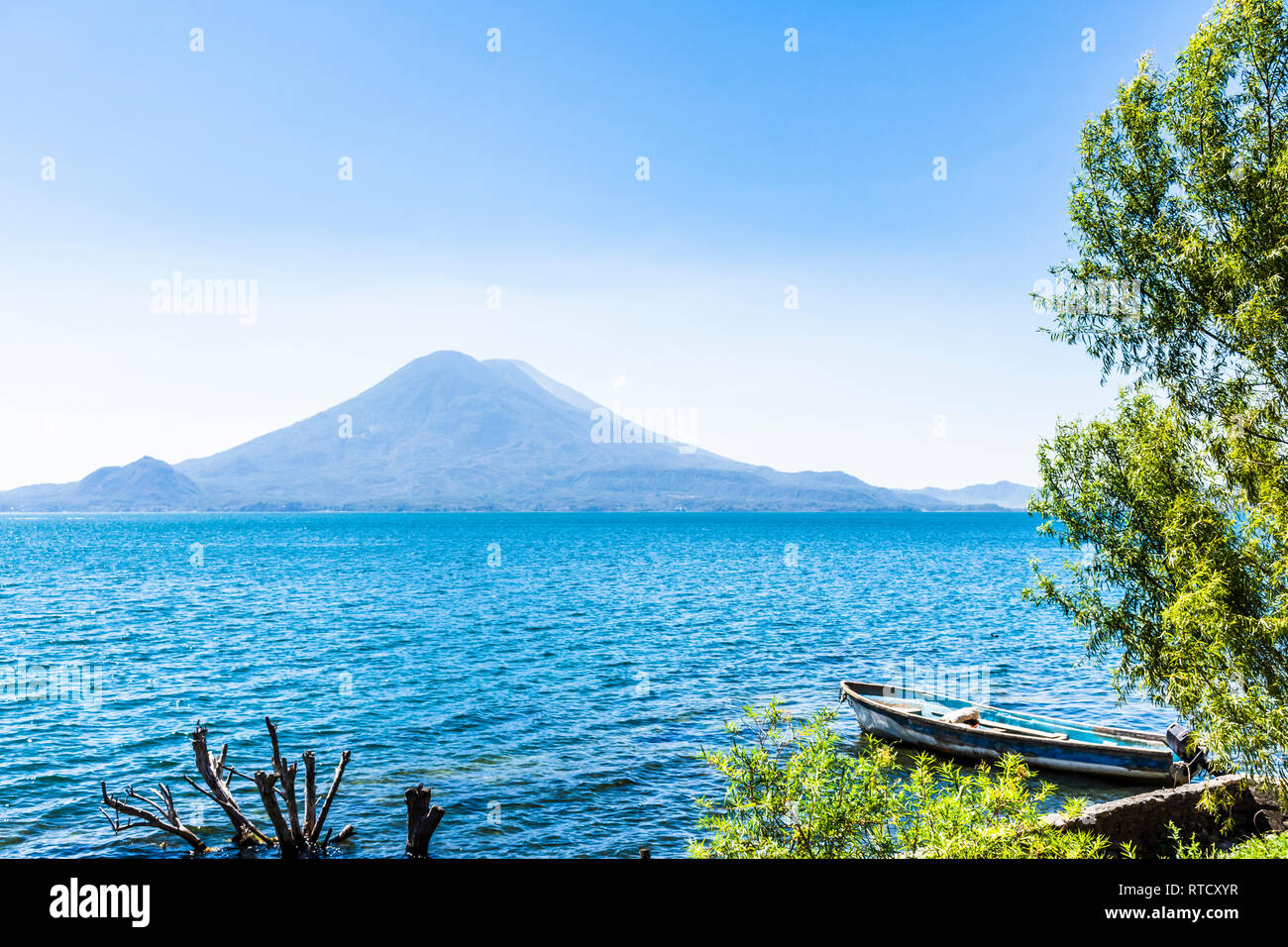 Atitlan & Toliman volcanoes on Lake Atitlan with boat moored in ...