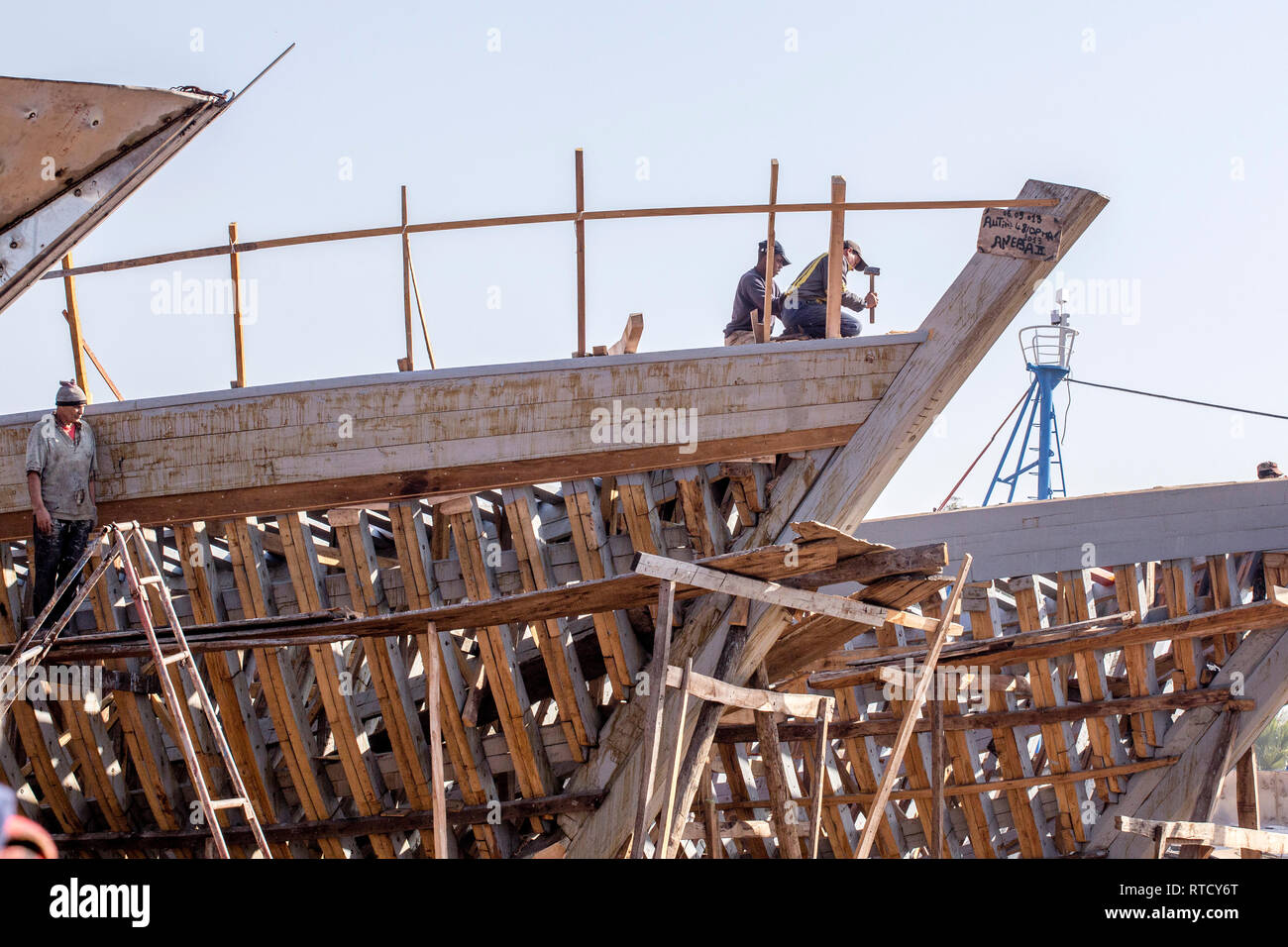 Shipwrights at work using simple tools to build wooden fishing boats by ...