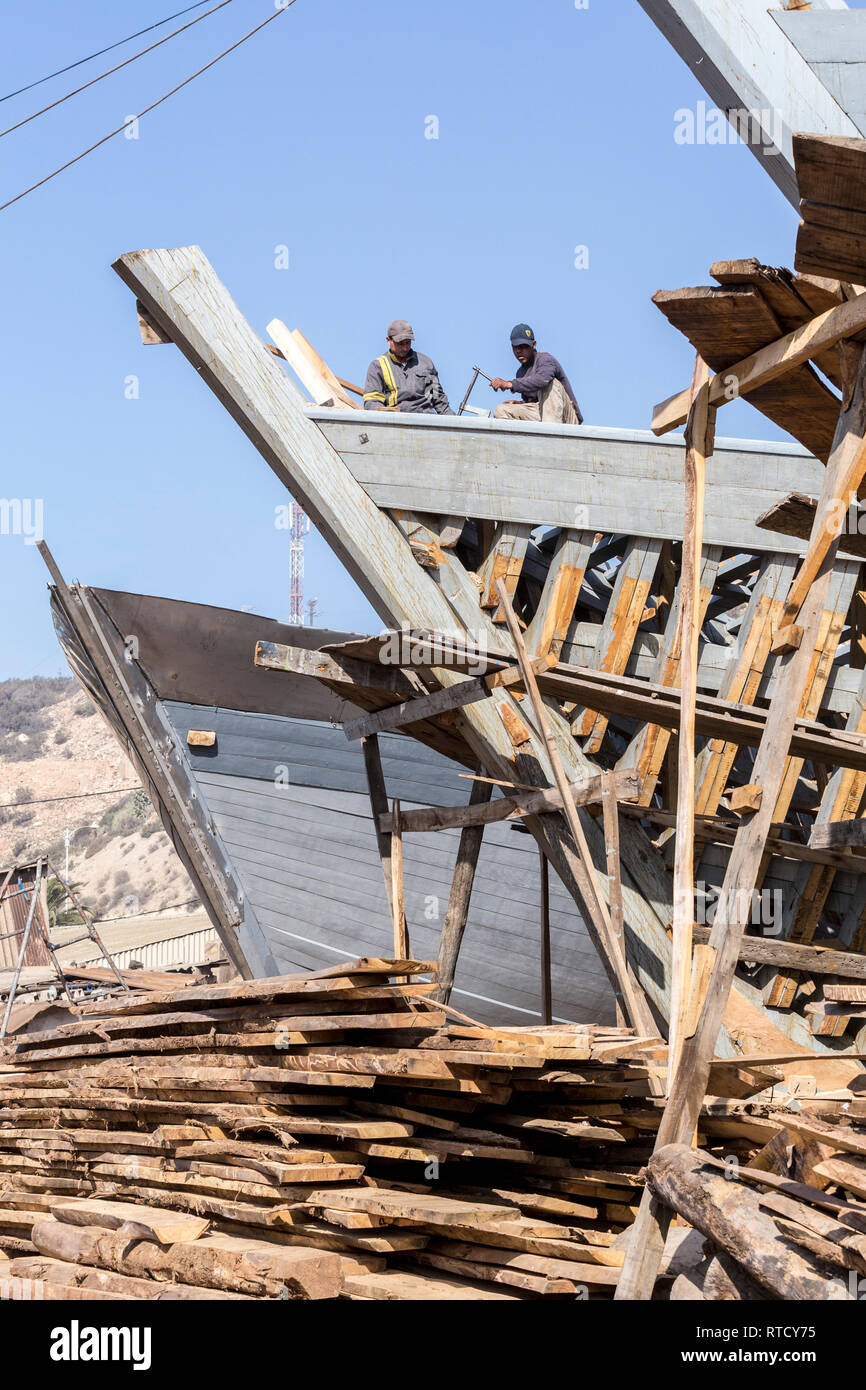 Shipwrights at work using simple tools to build wooden fishing boats by ...