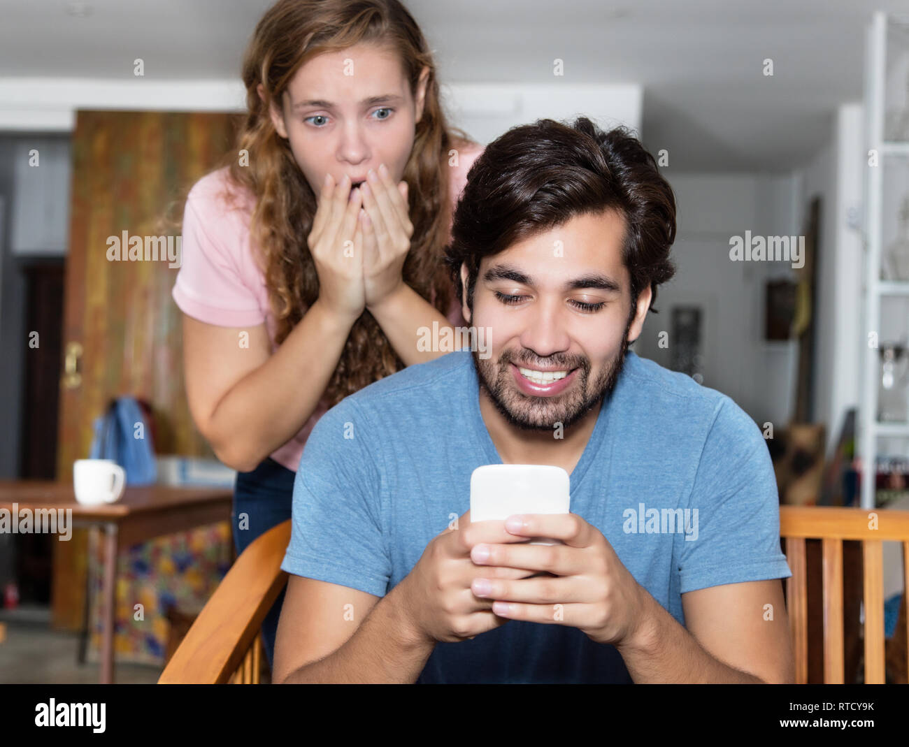 Cheating hipster man with shocked blond girlfriend Stock Photo - Alamy