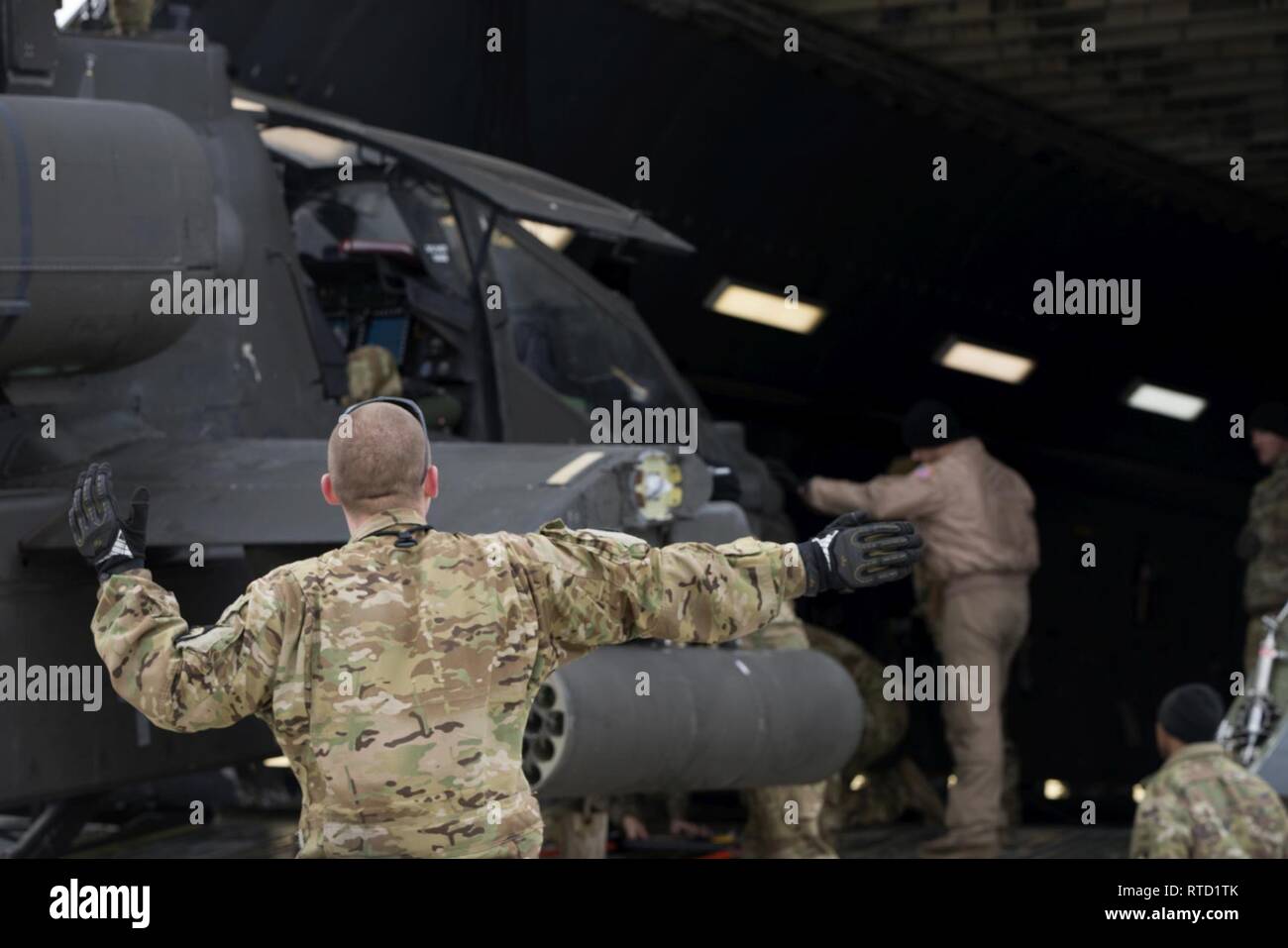 Airmen, Soldiers, and personnel prepare to load Apache Helicopters into ...