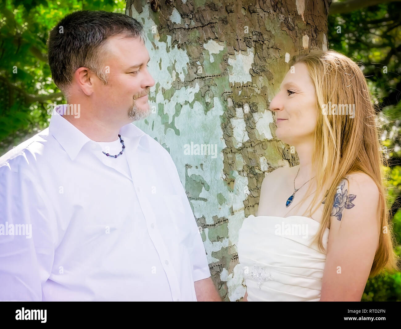 A young Caucasian couple poses for portraits after their wedding at ...