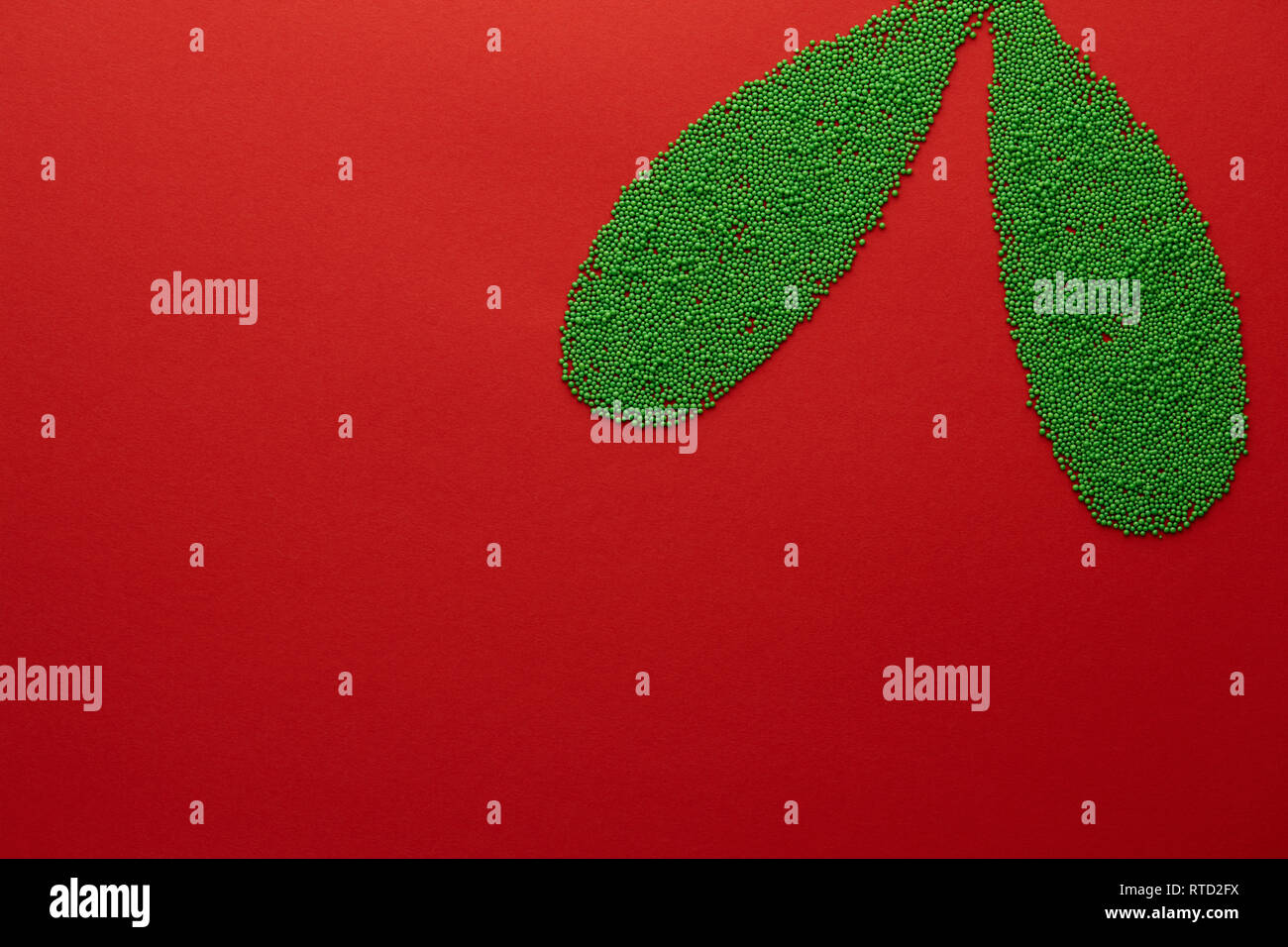 Easter bunny ears shape made from green sugar sprinkles on red ...