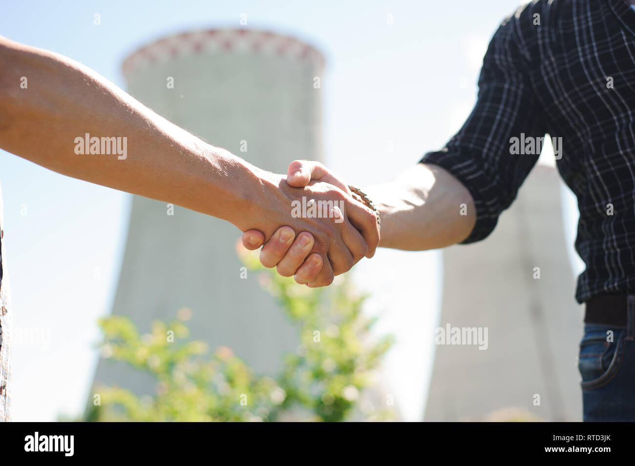 Two power line tower workers with handshaking Stock Photo - Alamy