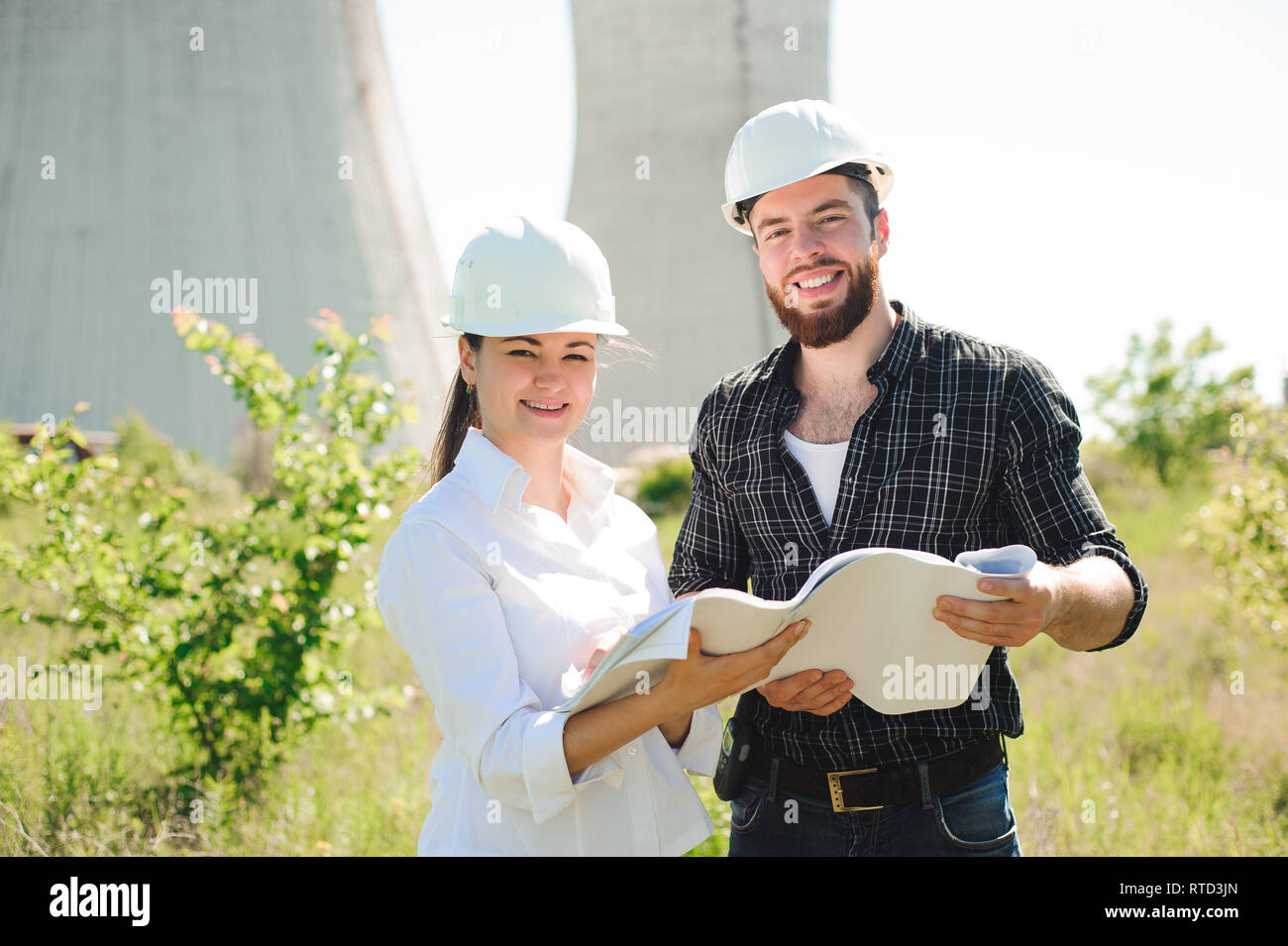 Two engineers standing at electricity station, discussing plan Stock ...