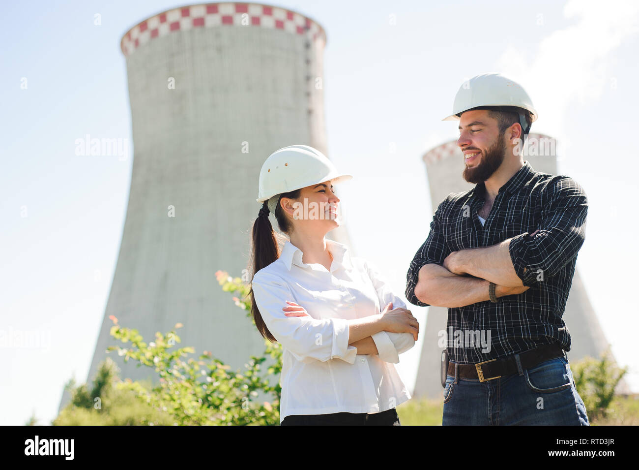 Two workers wearing protective helmet works at electrical power station ...