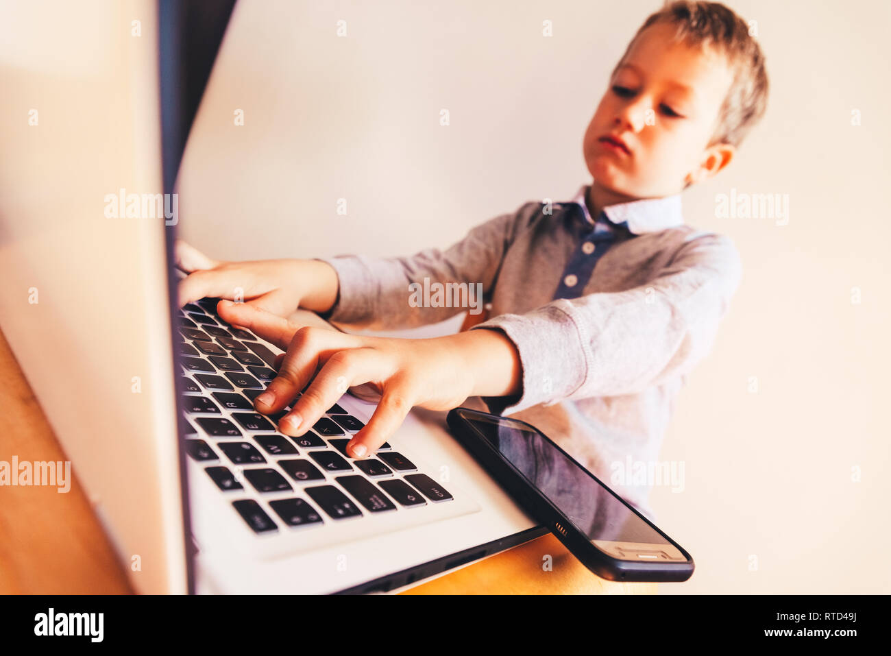 Child working with his computer in his business, concentrated typing to ...
