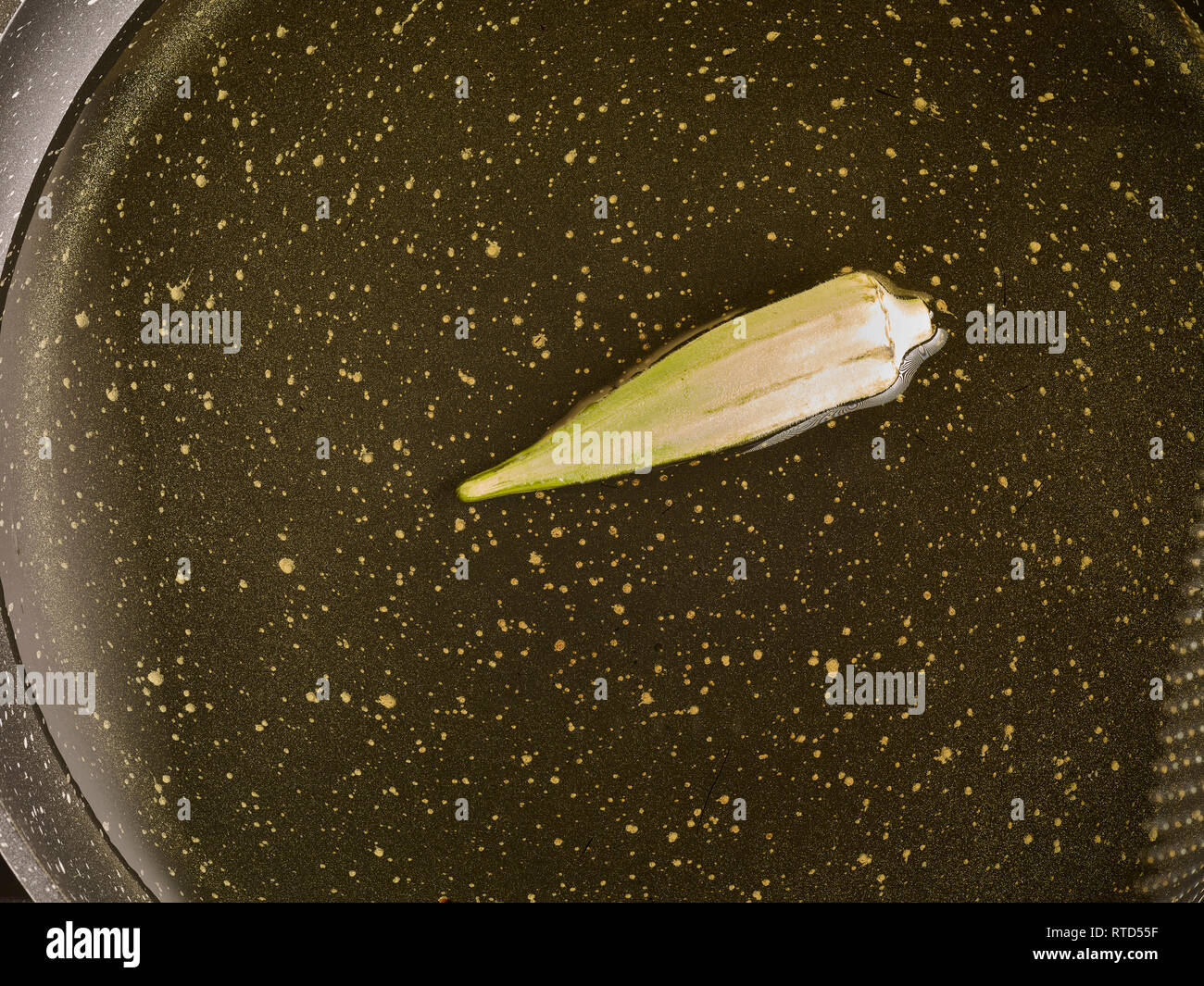 Spiced Okra frying in clean oil against a dark background food ...
