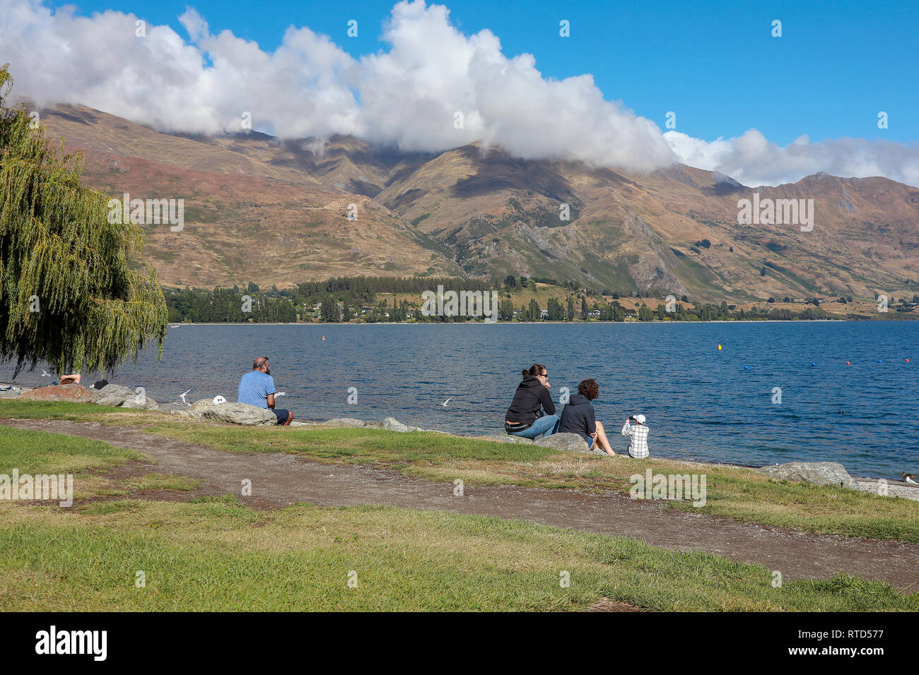 tourists or locals sitting talking taking pictures on the beach in the ...