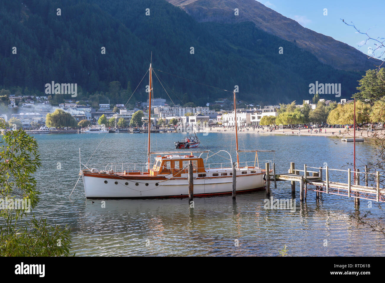 Sailing boat and tender tied to jetty in Lake Wakatipu, Queenstown ...