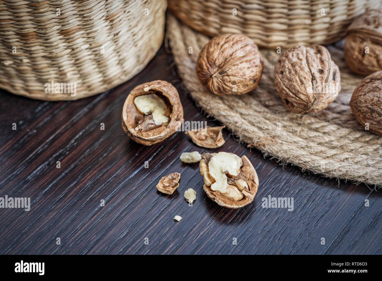 Close-up view of walnut kernels and whole walnuts scattered on a dark ...