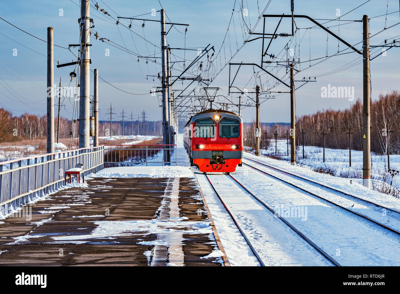 Local passenger train approaches to the station at winter morning time ...