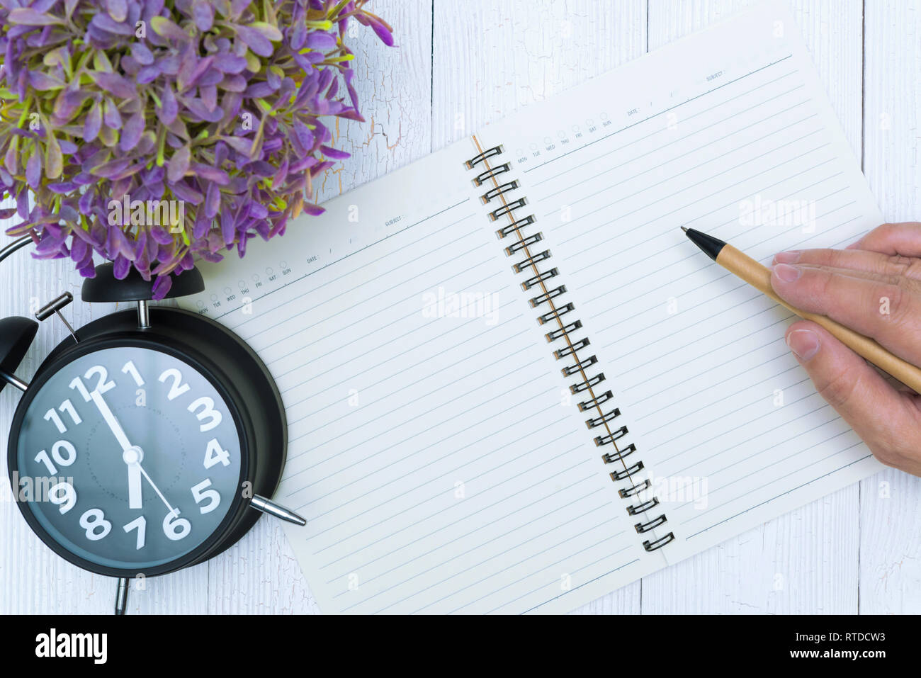 Man hand writing on blank page of notebook paper with pen on the wood ...