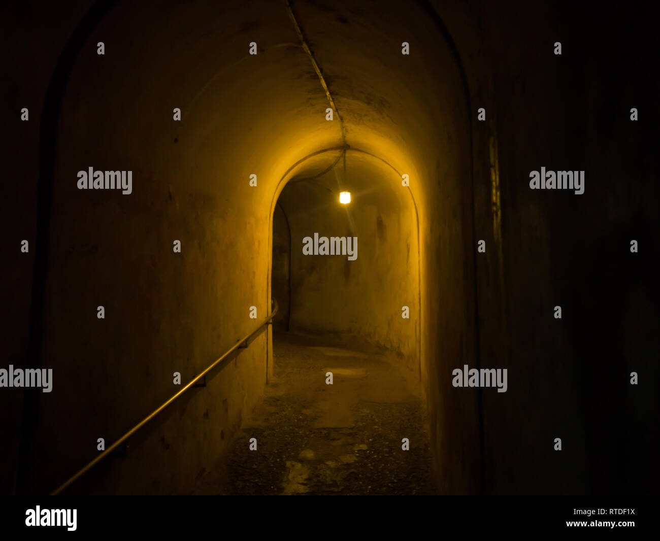 Yellow light in a dark tunnel Stock Photo - Alamy