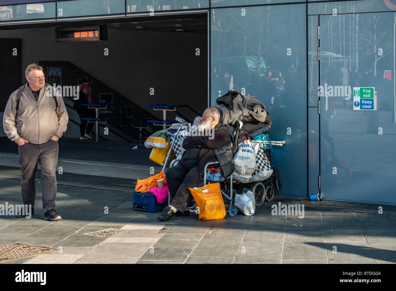 Old Homeless man sitting in his chair surounded by all his many items ...