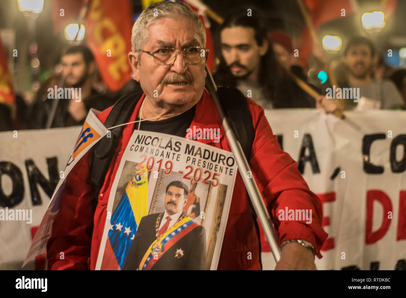 A protester seen holding a flag and a placard with a photo of Nicolas ...