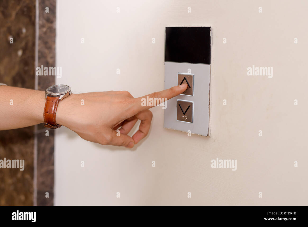 Person pushing up arrow elevator button Stock Photo - Alamy