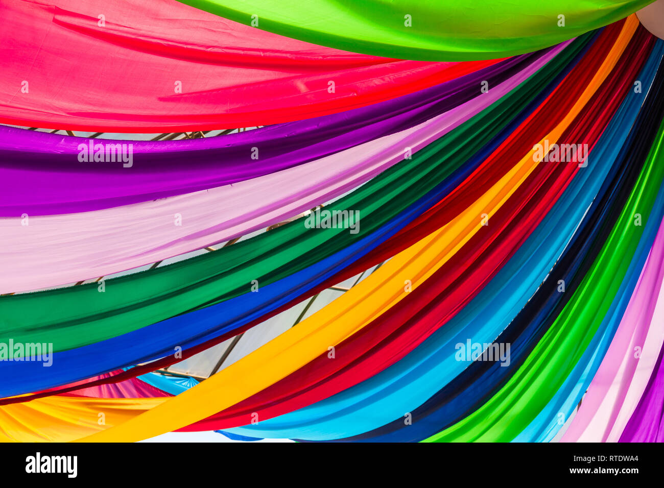 Fabrics of various colors hanging from a ceiling Stock Photo - Alamy