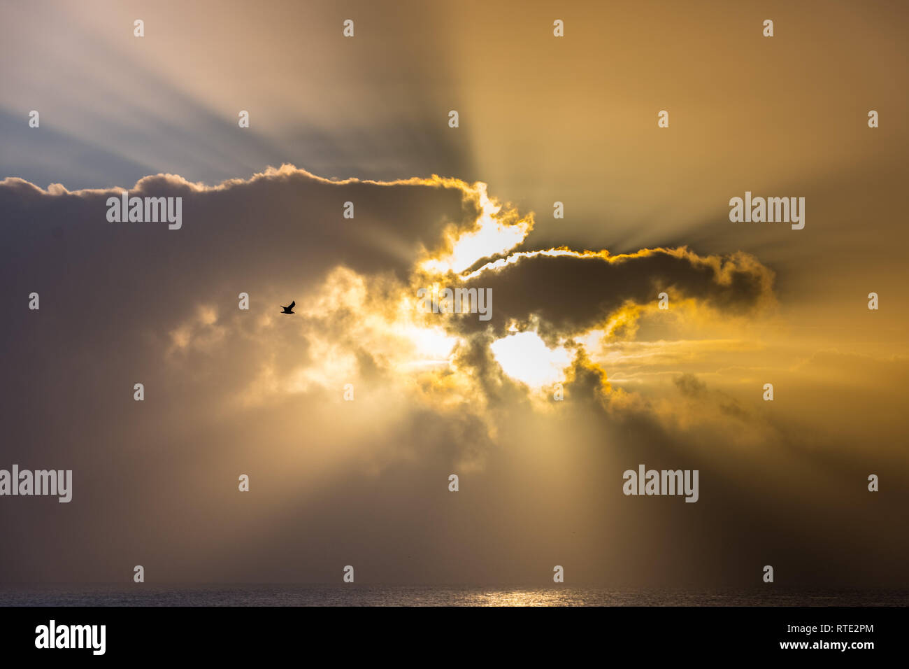 The sun beaming out behind a cloud Stock Photo - Alamy