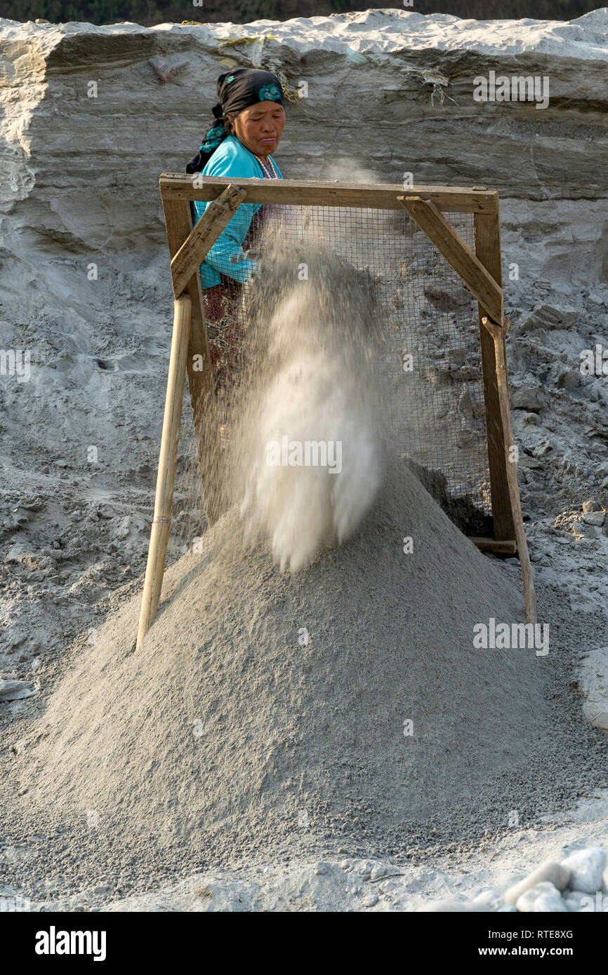 A lady seen filtering rocks on the banks of the river Seti, Pokhara ...