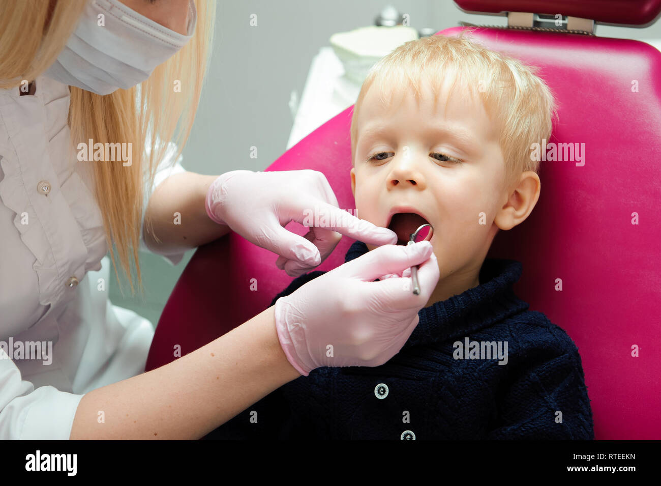 female dentist examines the teeth of the patient child. child mouth ...