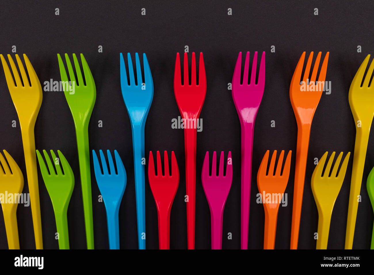 Many color plastic forks on a bright background Stock Photo - Alamy