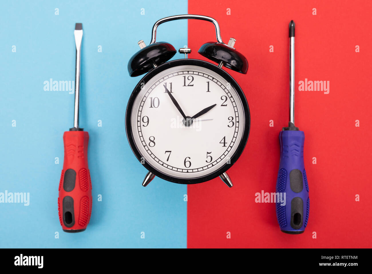 screw-drivers and black metal alarm clock on background Stock Photo - Alamy
