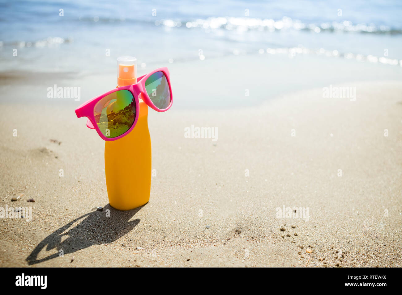 Various sunsreen products in the sand. cosmetic bottles for personal ...