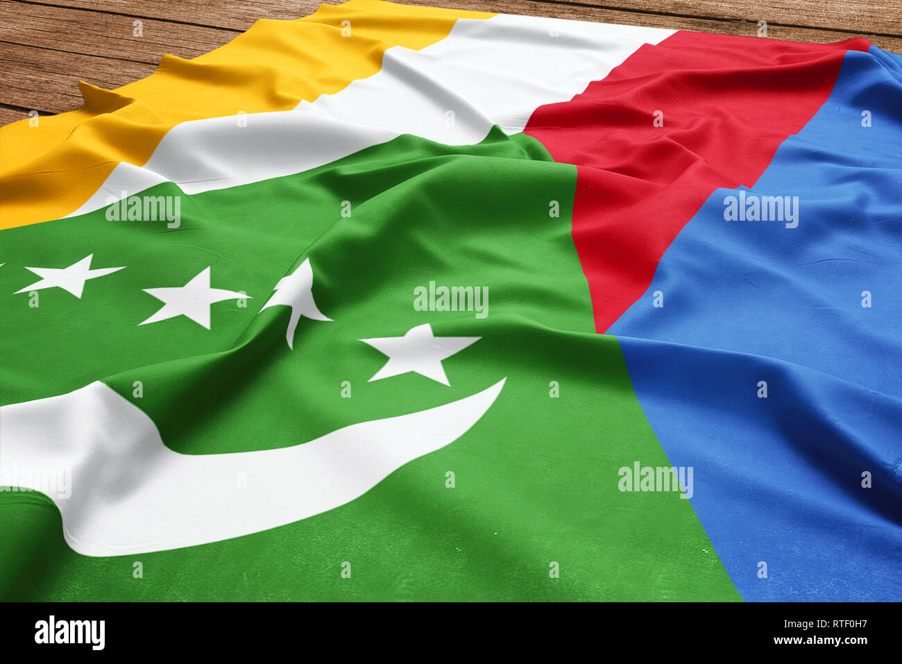 Flag of Comoros on a wooden desk background. Silk Comoran flag top view ...