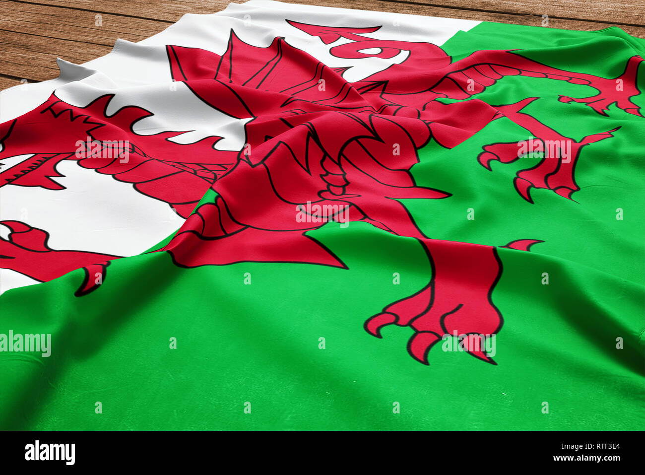 Flag of Wales on a wooden desk background. Silk Welsh flag top view ...
