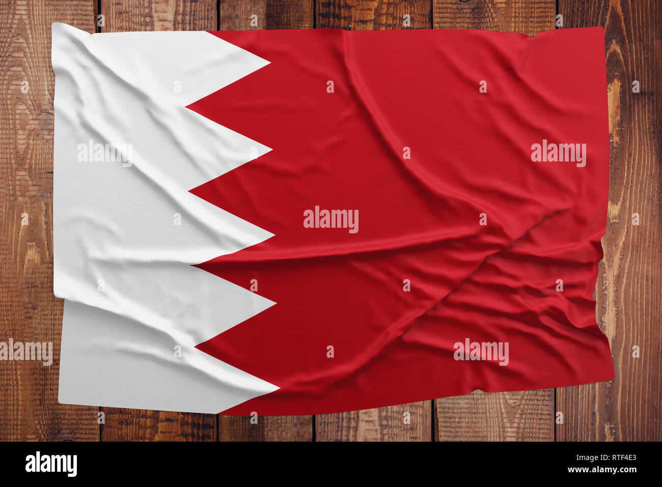 Flag of Bahrain on a wooden table background. Wrinkled Bahraini flag ...